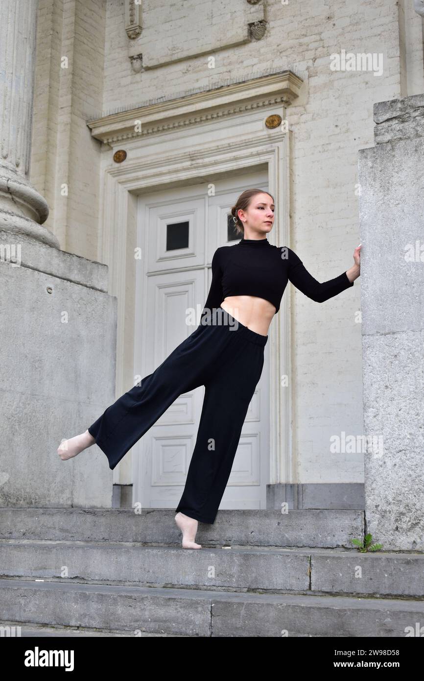 Young woman in black outfit performing a contemporary dance move on ...