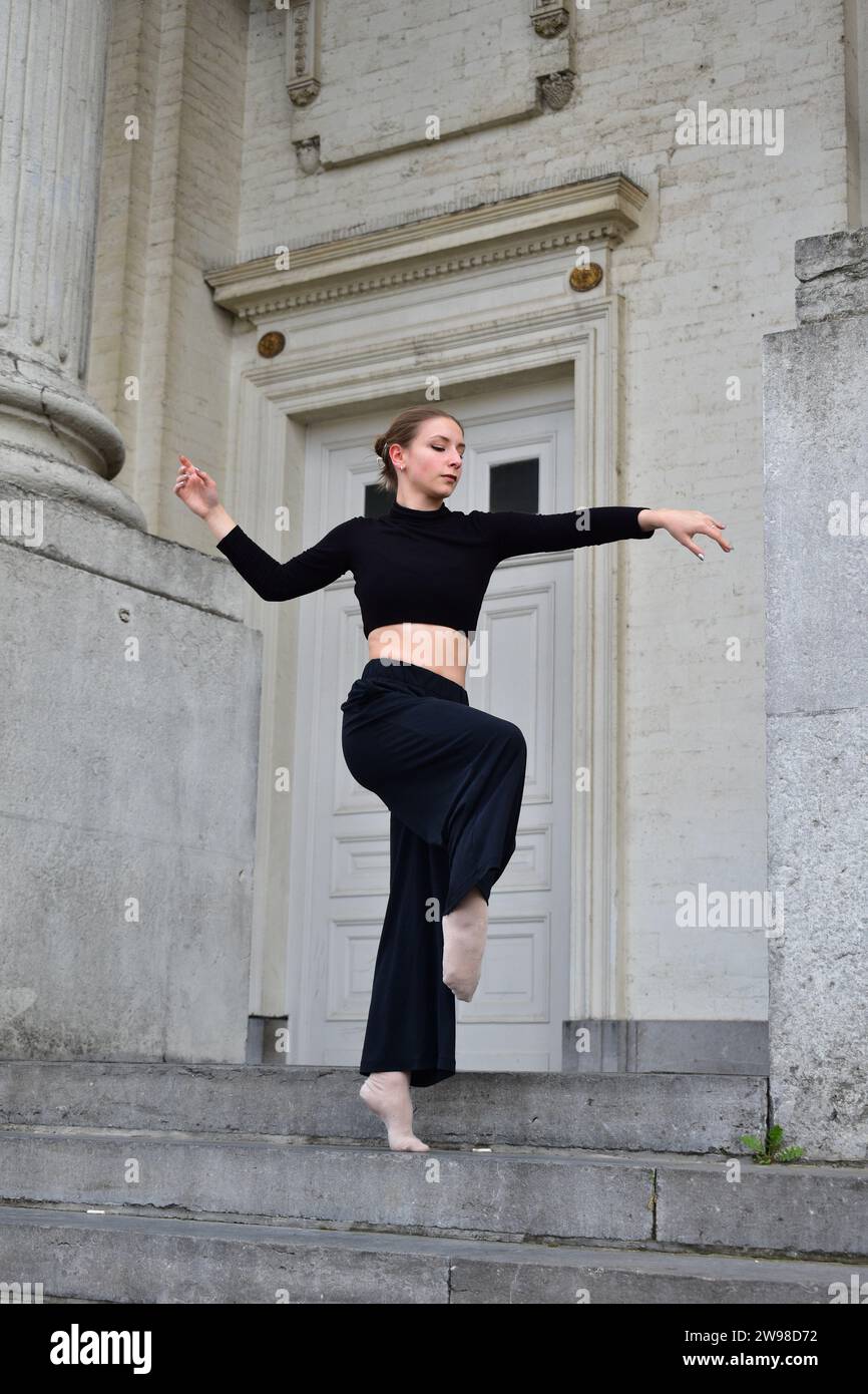 Young woman in black outfit performing a contemporary dance move on ...