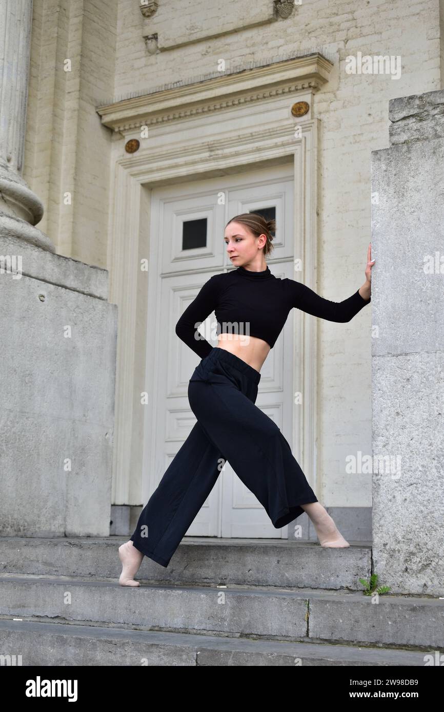 Young woman in black outfit performing a contemporary dance move on ...