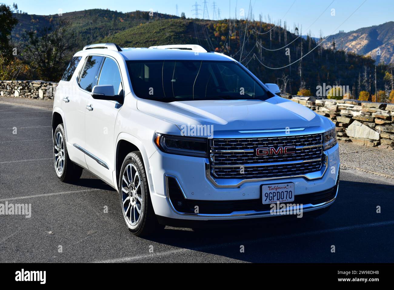 A white GMC Acadia SUV car parked during sunset with Californian ...