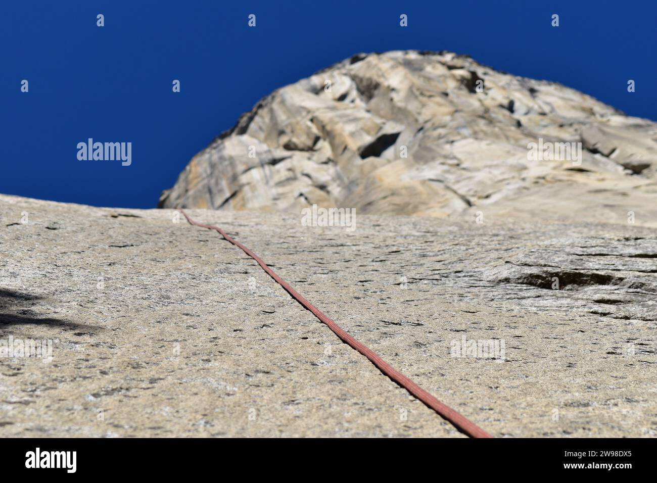 Climbing rope resting against the granite rock wall of El Capitan in ...