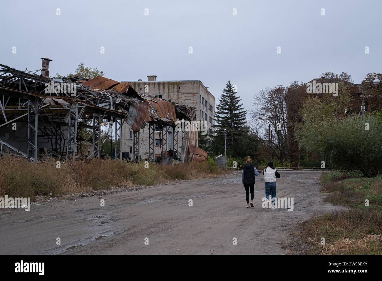 Two girls walking in front of the Kupiansk mechanical works. On 10th ...