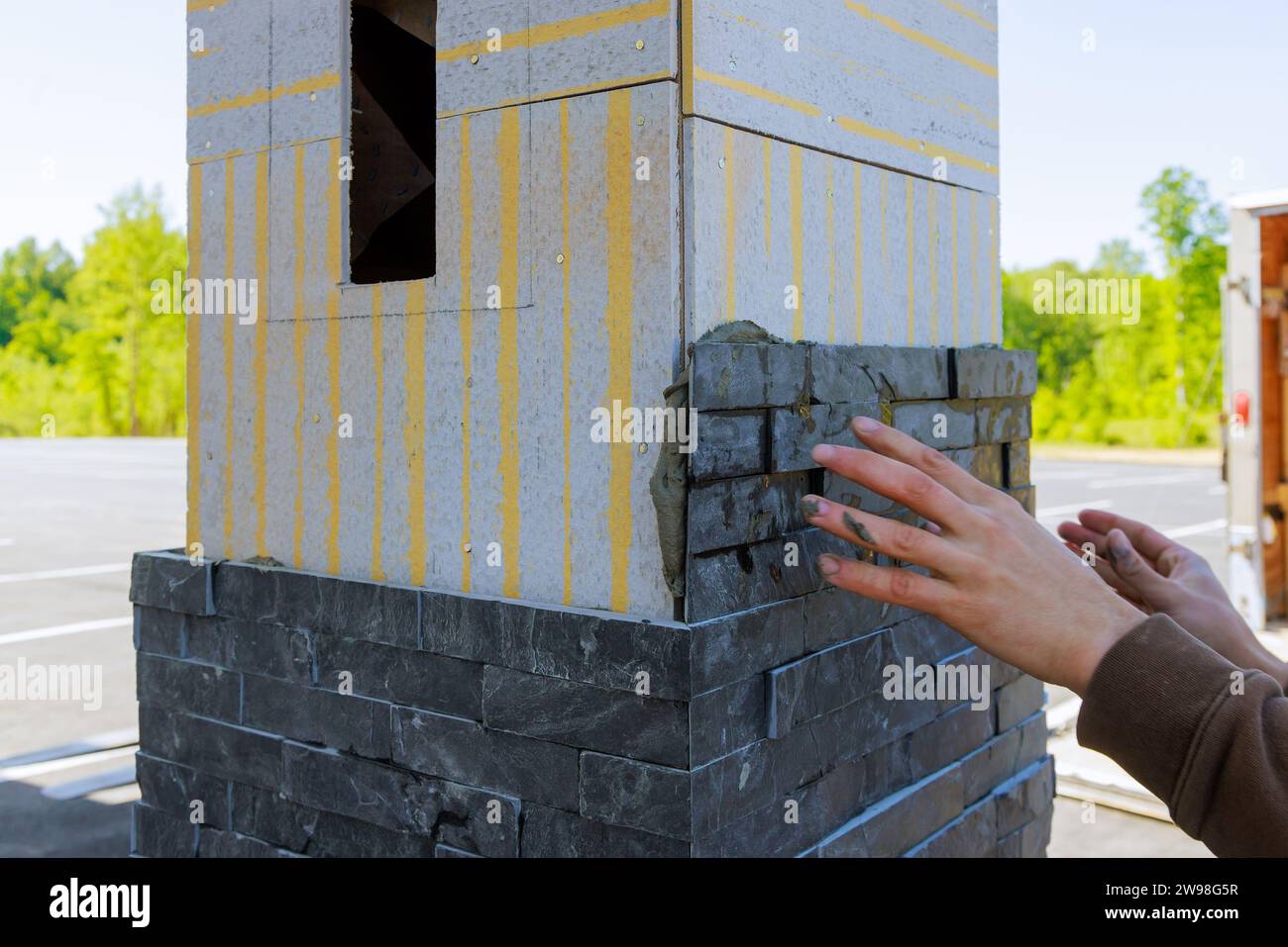 Installation of facing tiles on building columns by tiler Stock Photo ...
