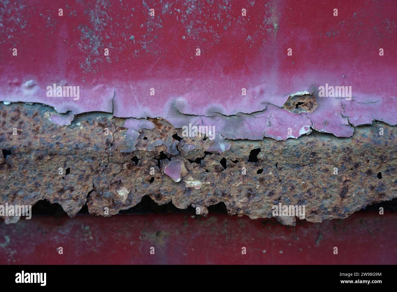 a piece of rusty metal painted red Stock Photo - Alamy