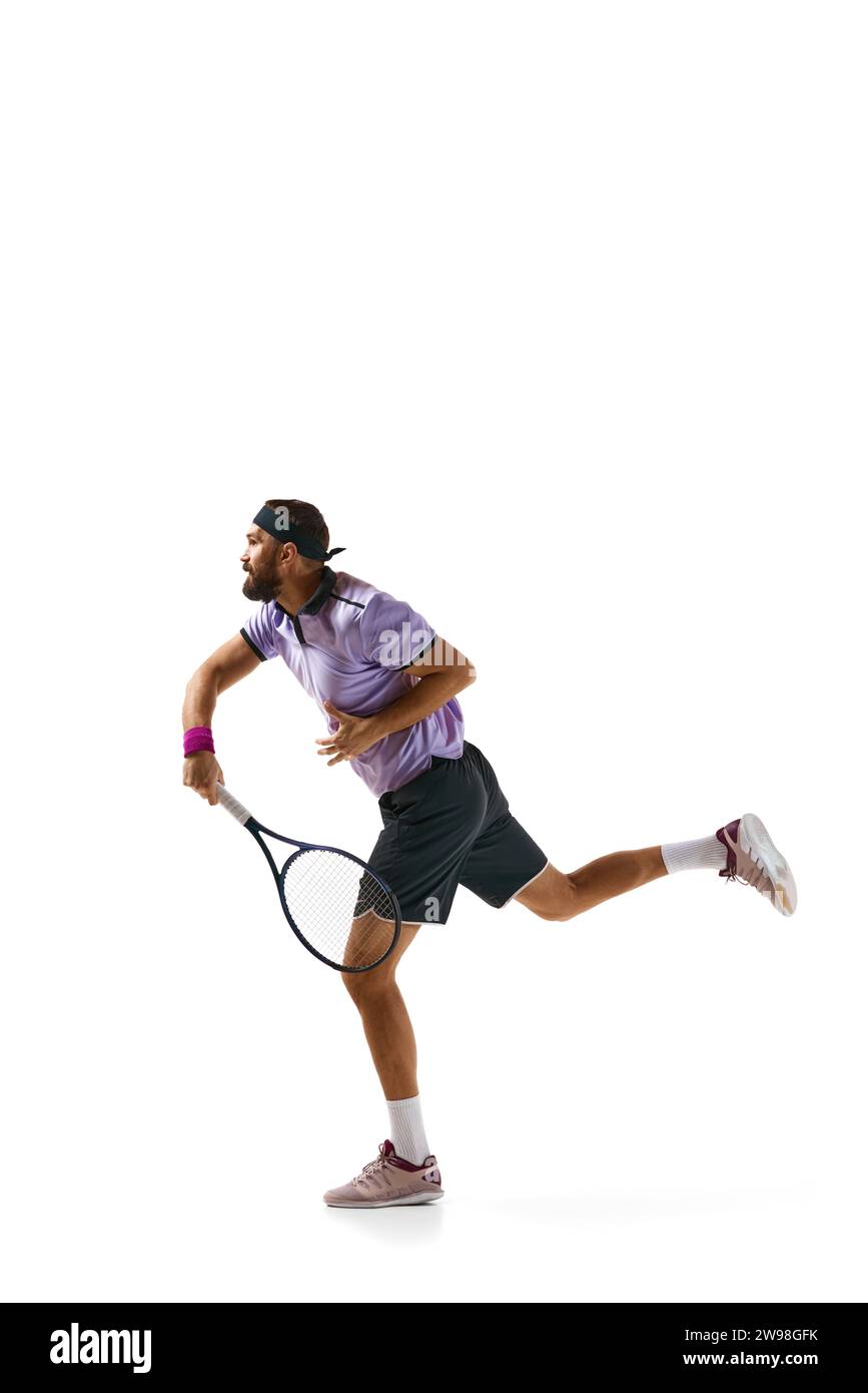 Full-length image of athletic young man, tennis player in motion with ...