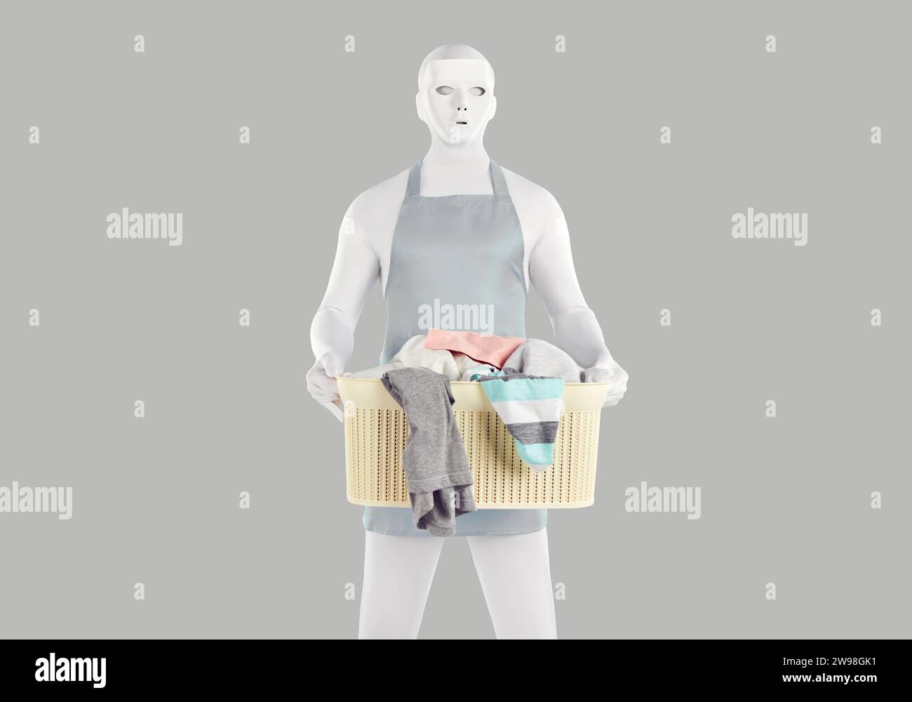 Man disguised in white bodysuit, mask and apron holding laundry basket ...