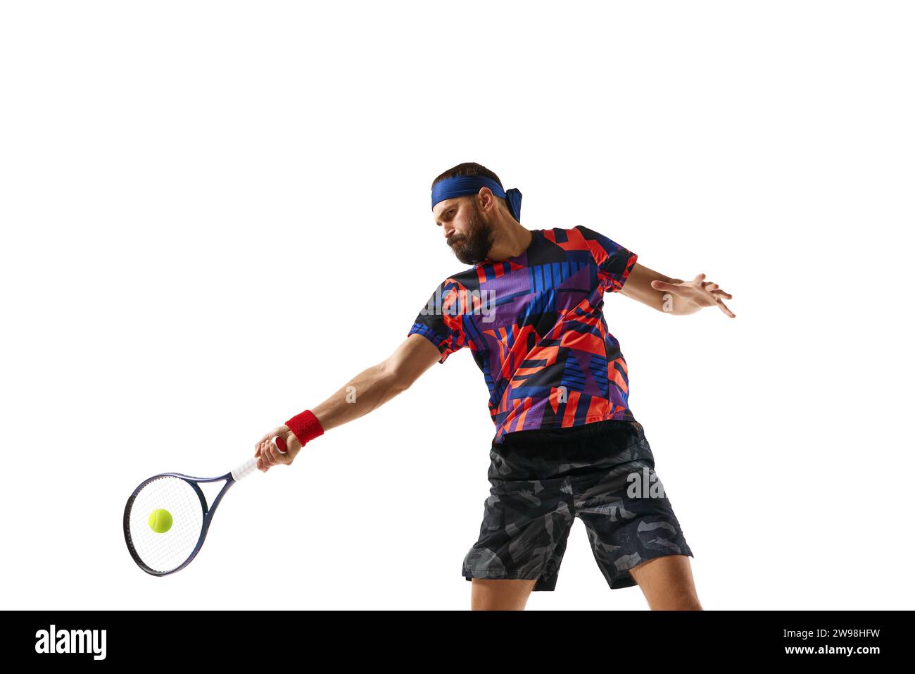 Concentrated bearded young man, tennis player hitting ball with racket ...