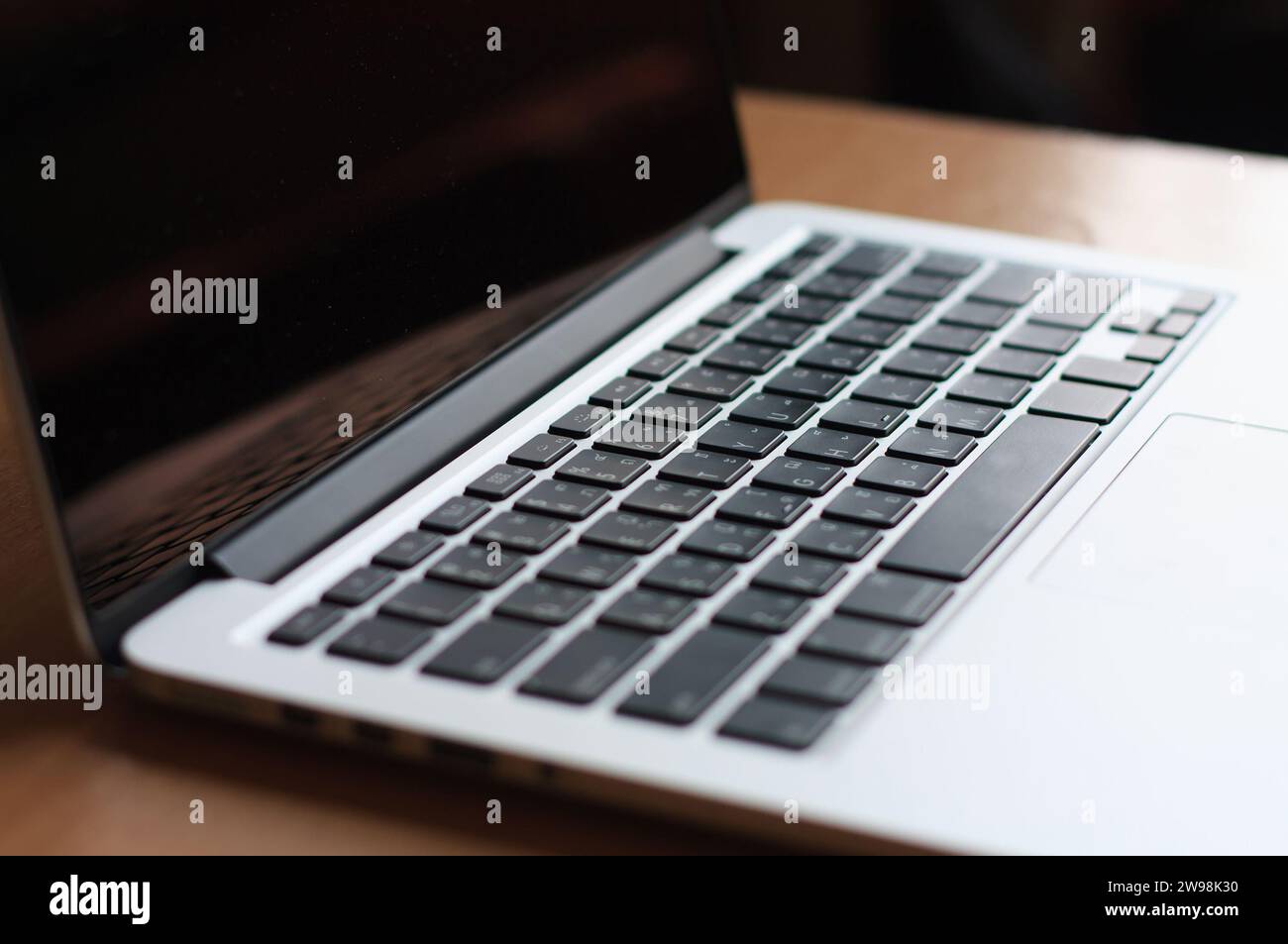 open laptop with black screen on modern wooden desk, angled notebook on ...