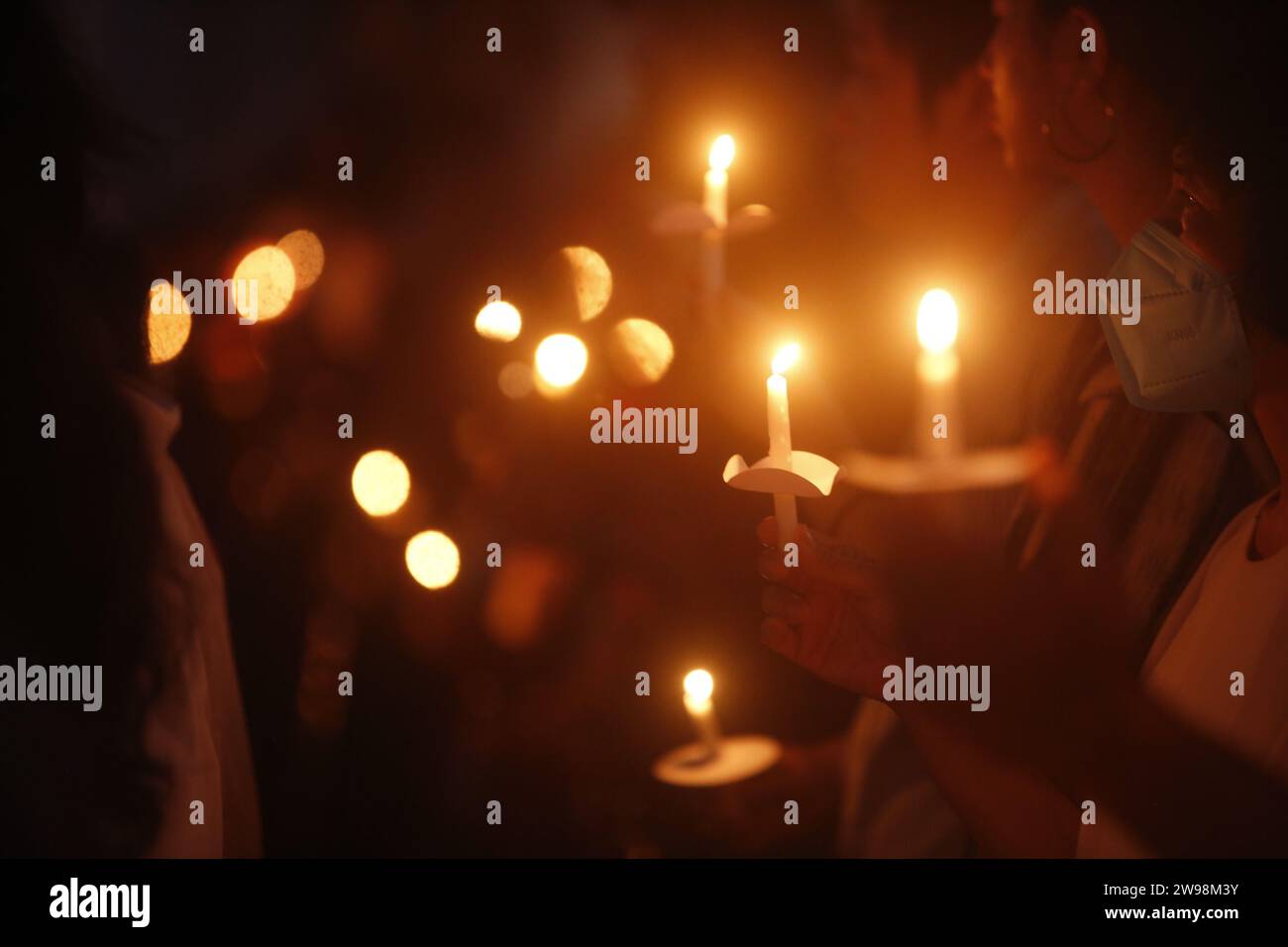 Catholic faithful hold candles while attending Christmas Eve Mass at a ...