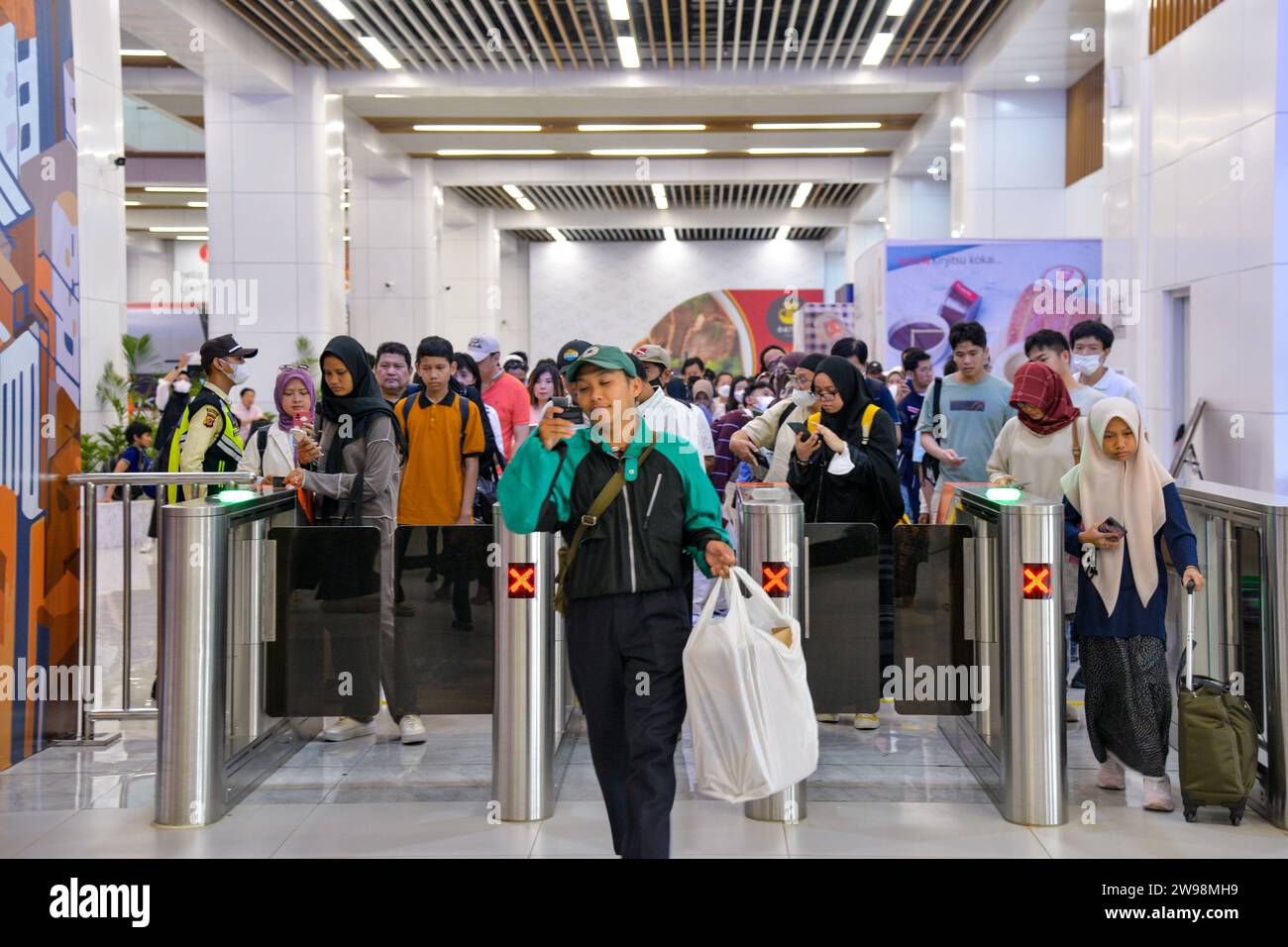 Jakarta, Indonesia. 25th Dec, 2023. Passengers use their tickets to ...