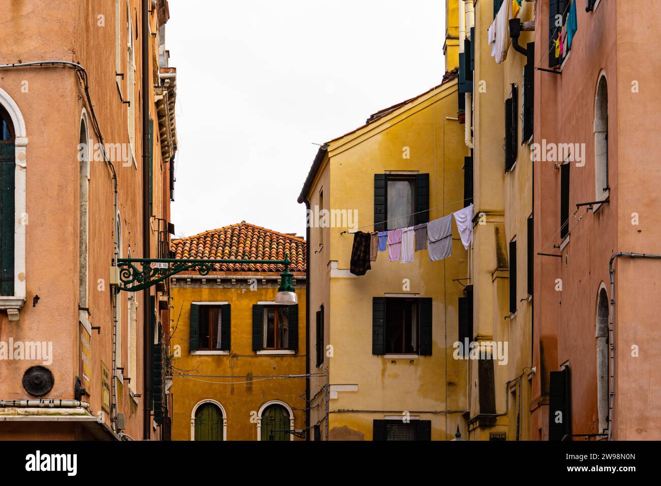 Facades of residential building with clothesline and window shutters in ...