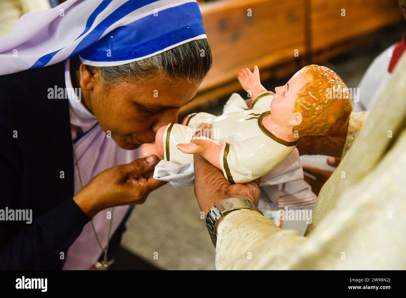 GUWAHATI,INDIA- DECEMBER 25: Devotee kisses the baby idol of Jesus ...