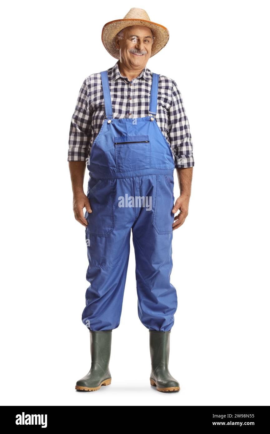 Mature farmer in overalls wearing gumboots and straw hat isolated on ...