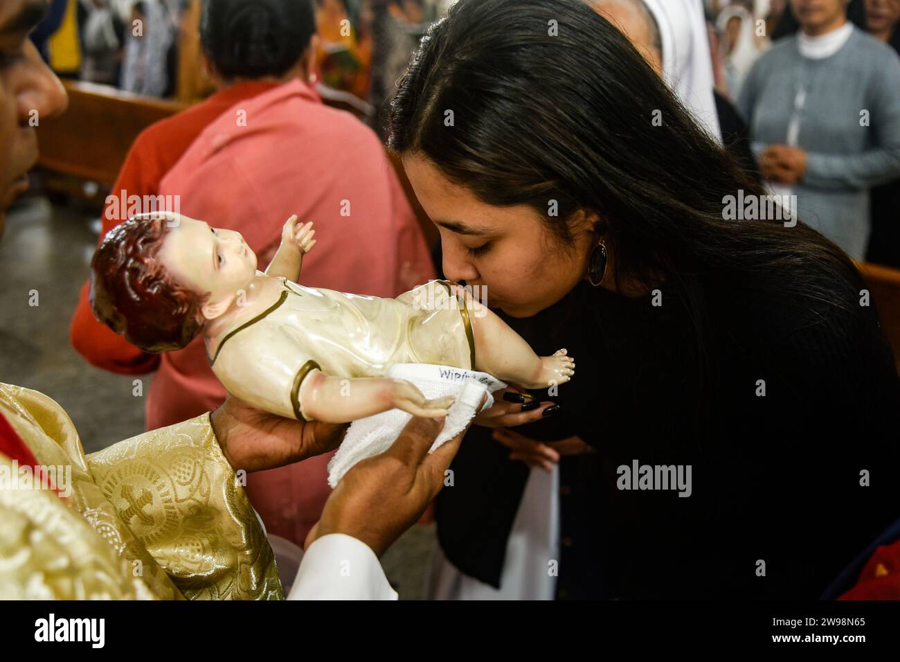 GUWAHATI,INDIA- DECEMBER 25: Devotee kisses the baby idol of Jesus ...