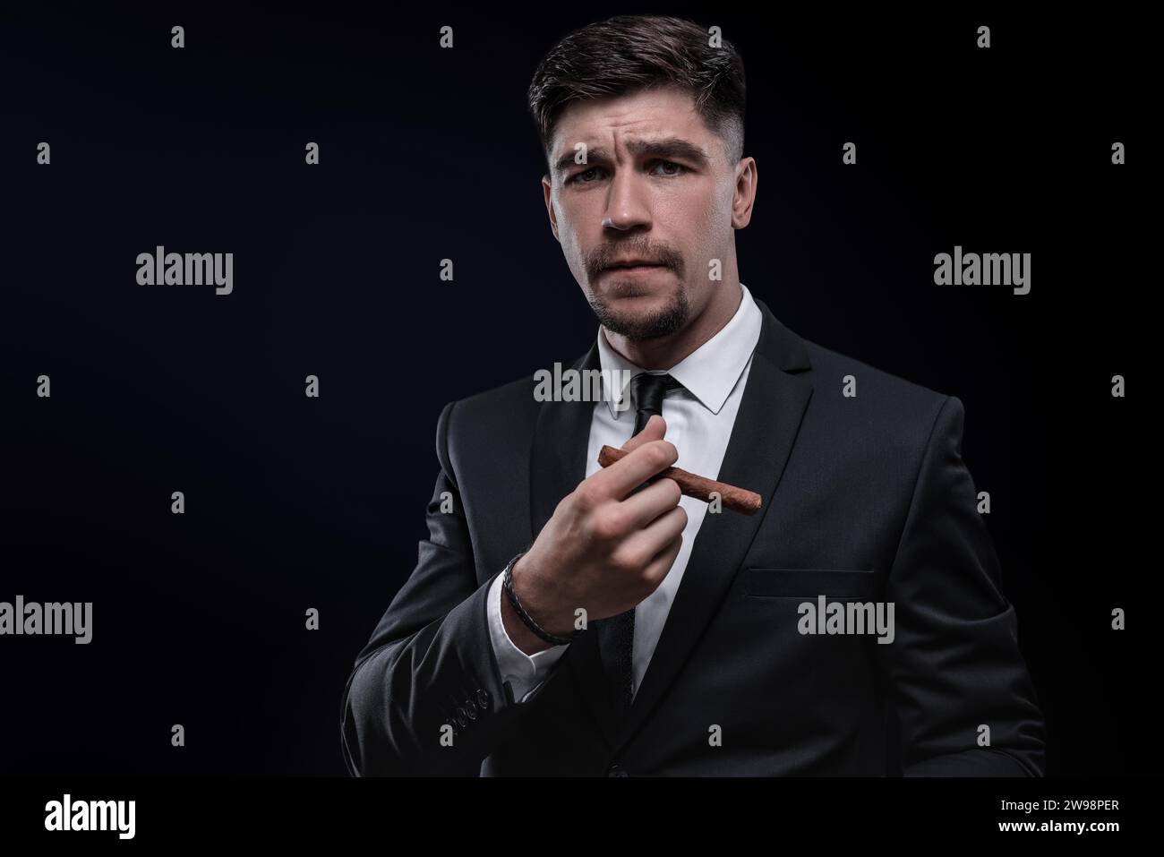 Portrait of a stylish man in a suit with a cigar. Business concept ...