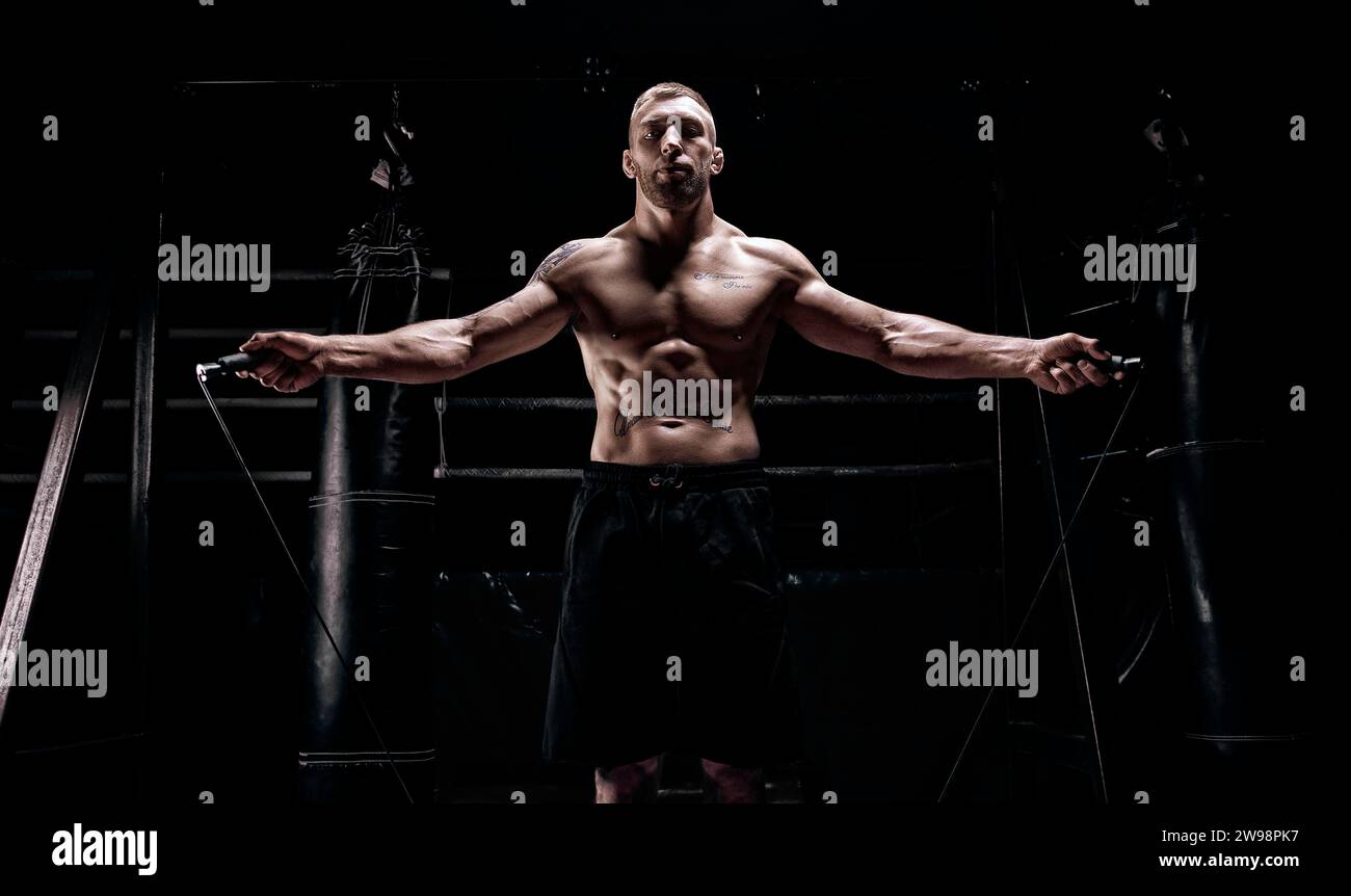 The athlete jumps on a skipping rope in the gym opposite the boxing ...