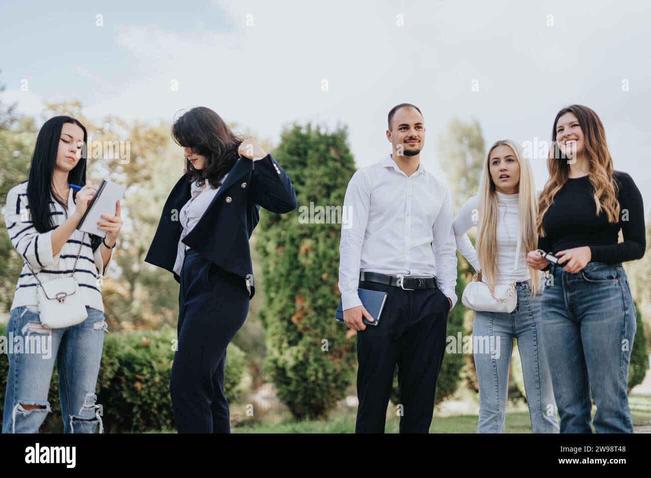 University students studying and discussing subjects together in a park ...