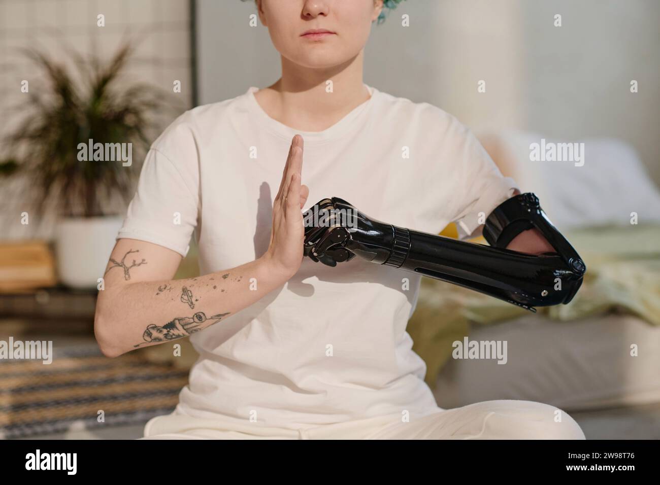 Cropped image of girl with cyber prosthetic arm making fist and palm ...