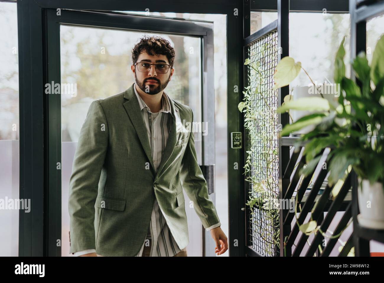 Good looking employee arriving at work. He is entering the office Stock ...