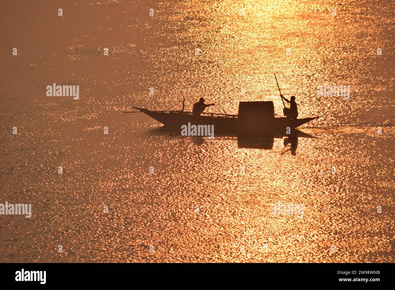 A boat on the golden river. Fishermen are fishing in the river at dawn ...