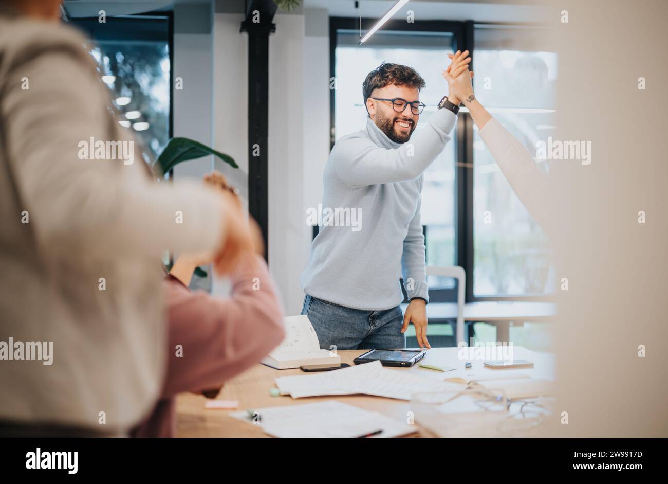 Colleagues celebrating successful project completion in office Stock ...