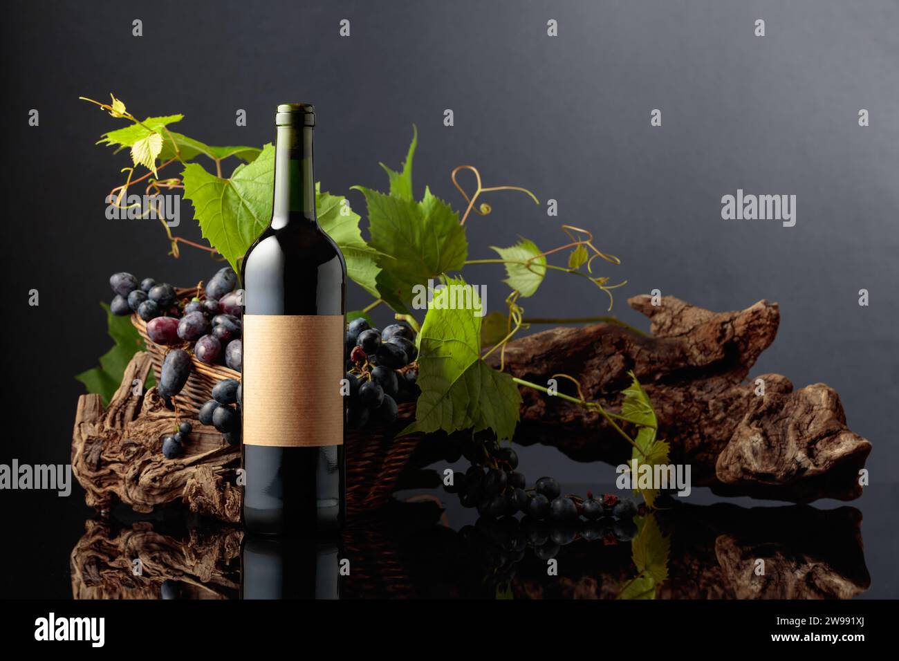 Bottle of red wine with blue grapes and vine branches. On a bottle old ...