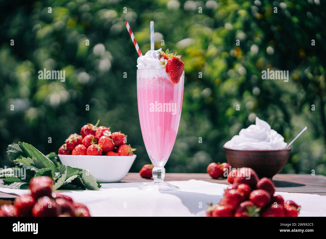 Still life - amazing strawberry milkshake cocktail with straw on nature ...