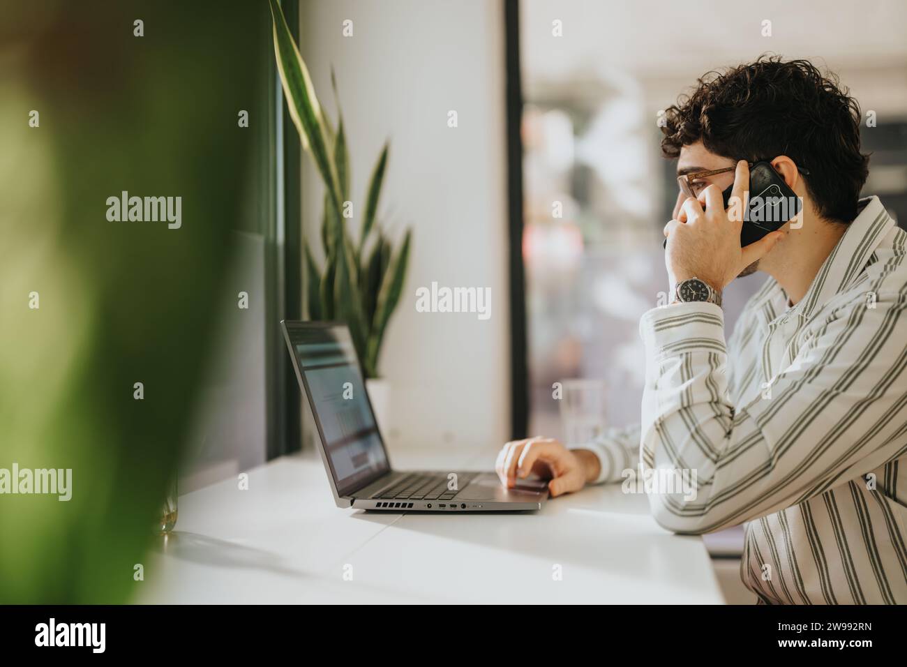 Business person having phone call while working on his individual tasks ...