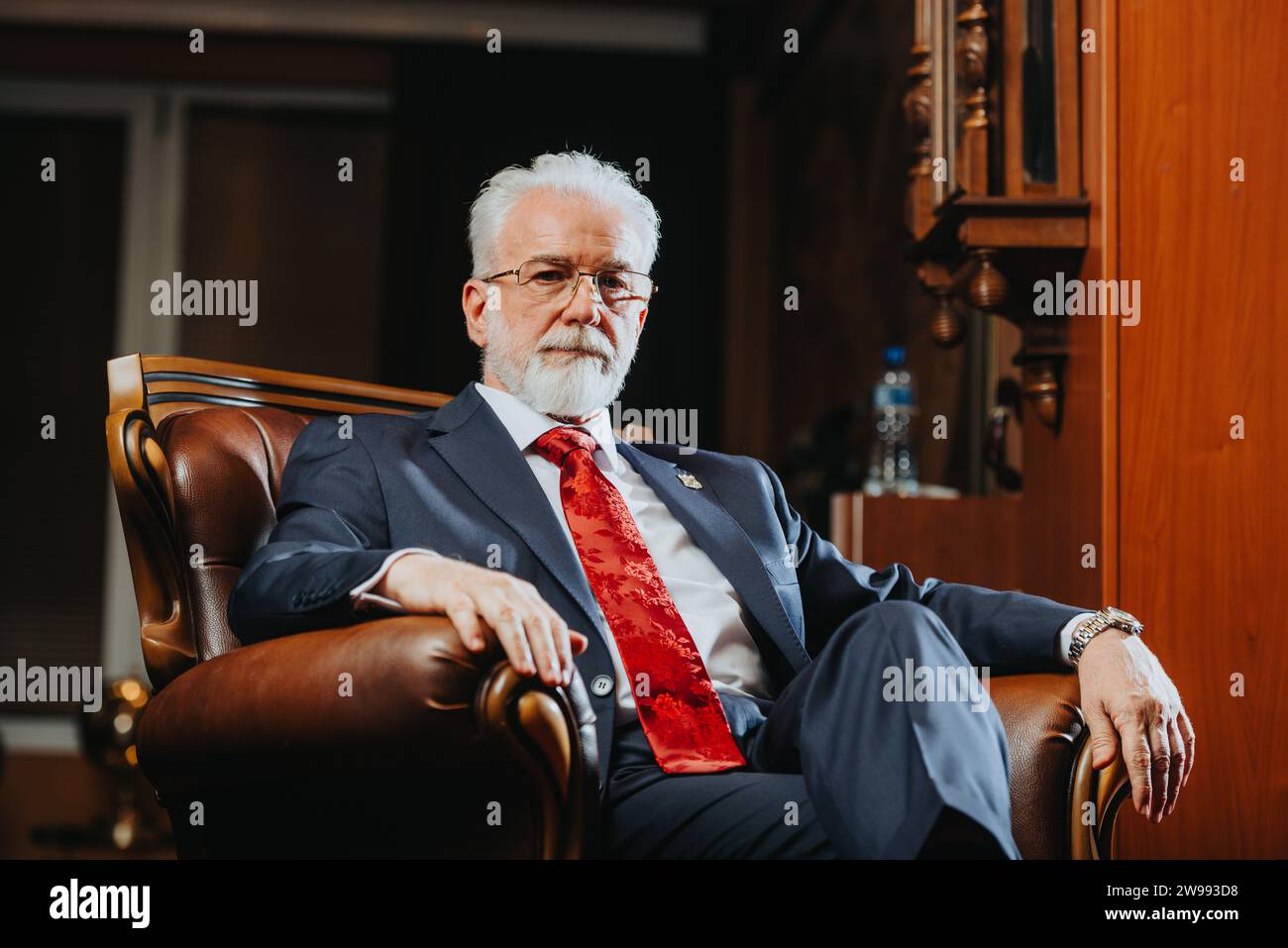 Experienced university rector poses with confidence sitting on modern ...