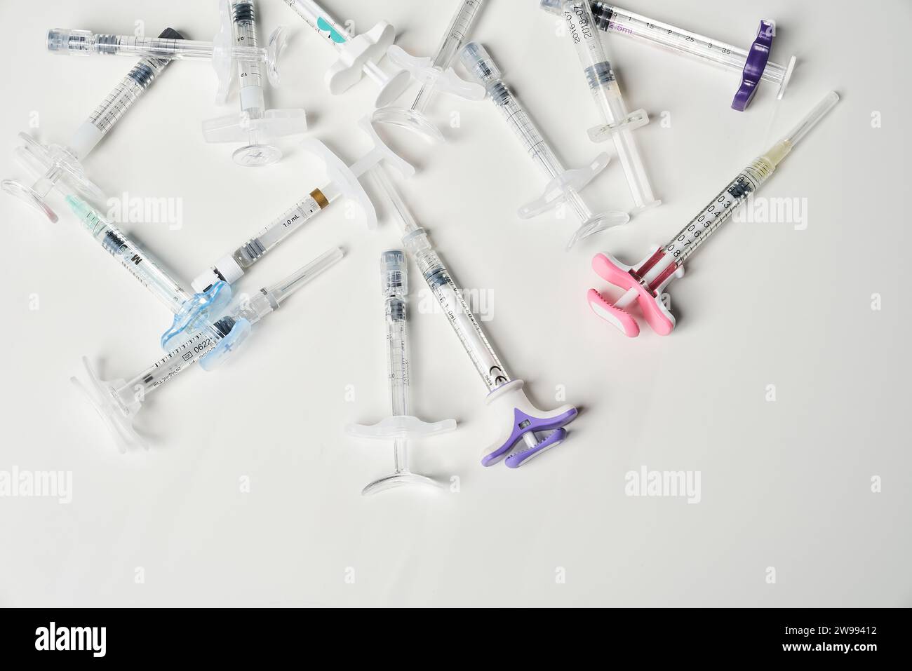 Syringes filled with liquid inside on white background. View from above ...