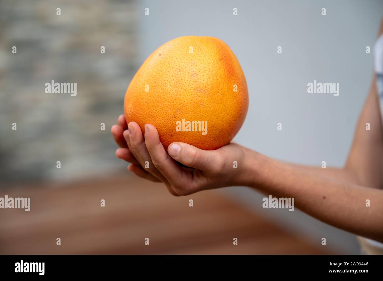Child holding bright citrus fruit close-up, freshness and healthy ...