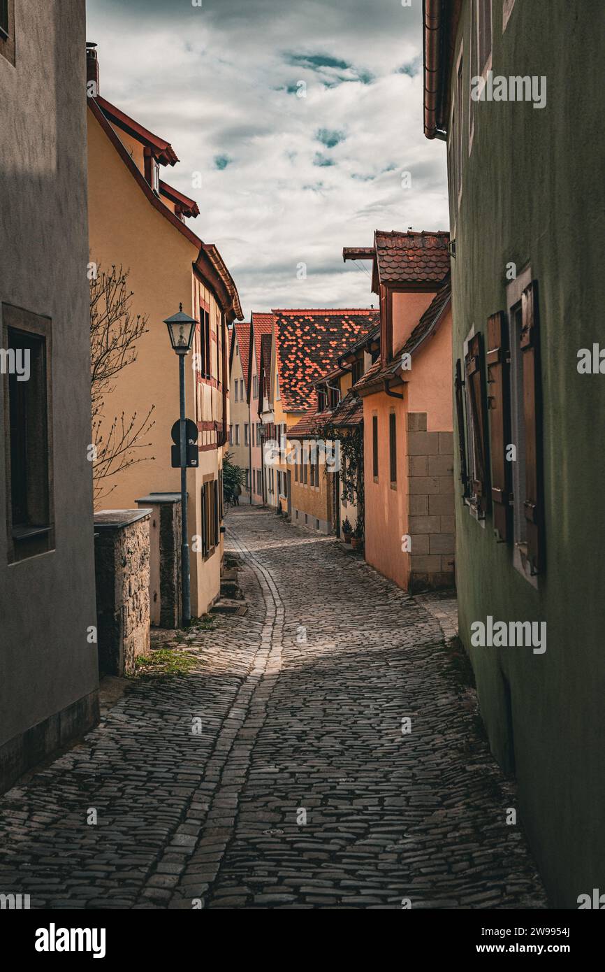 A scenic view of a narrow cobblestone pathway framed by two ancient ...
