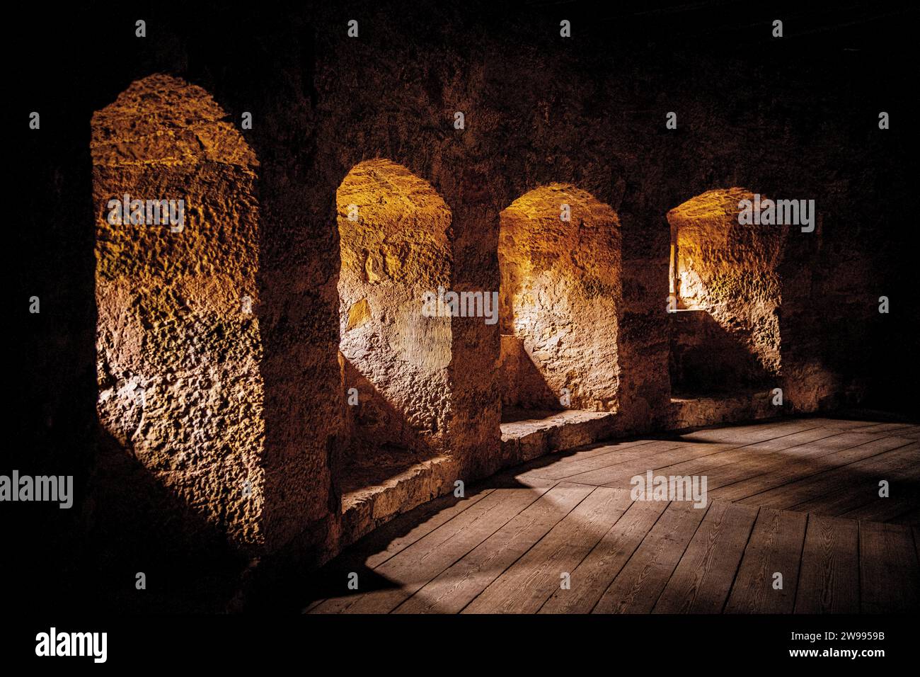 Three arches constructed from stone illuminated by light streaming ...