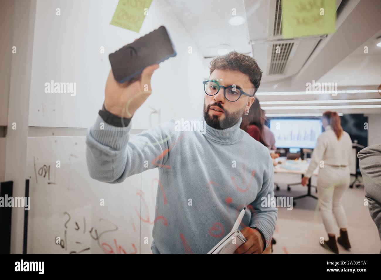 Young team collaborating in a modern office, brainstorming and planning ...