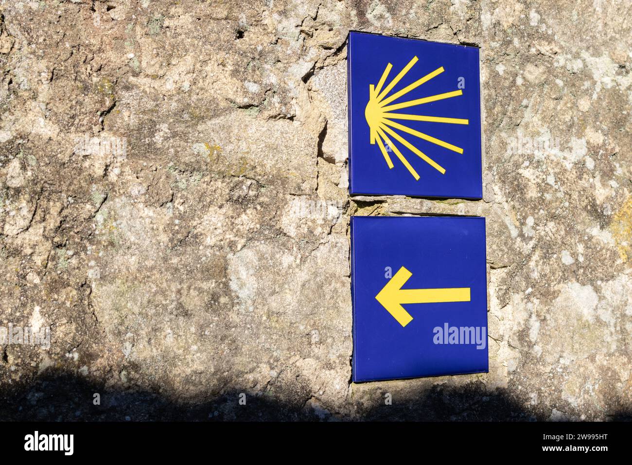 A closeup of Camino de Santiago tiles on antique stone wall Stock Photo ...