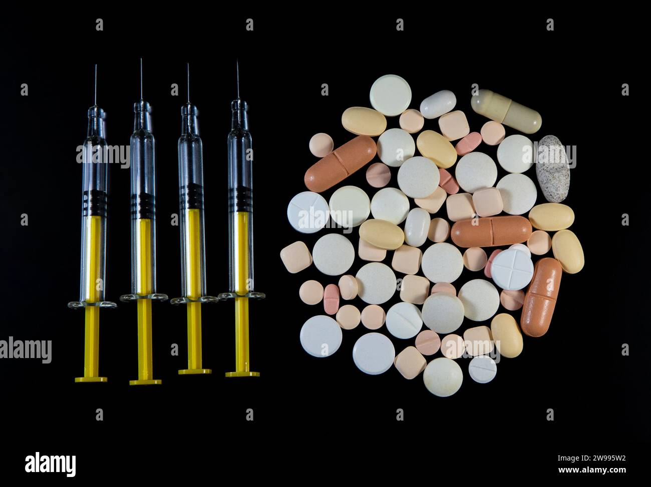 A top view of Syringes and pills on a black background Stock Photo - Alamy
