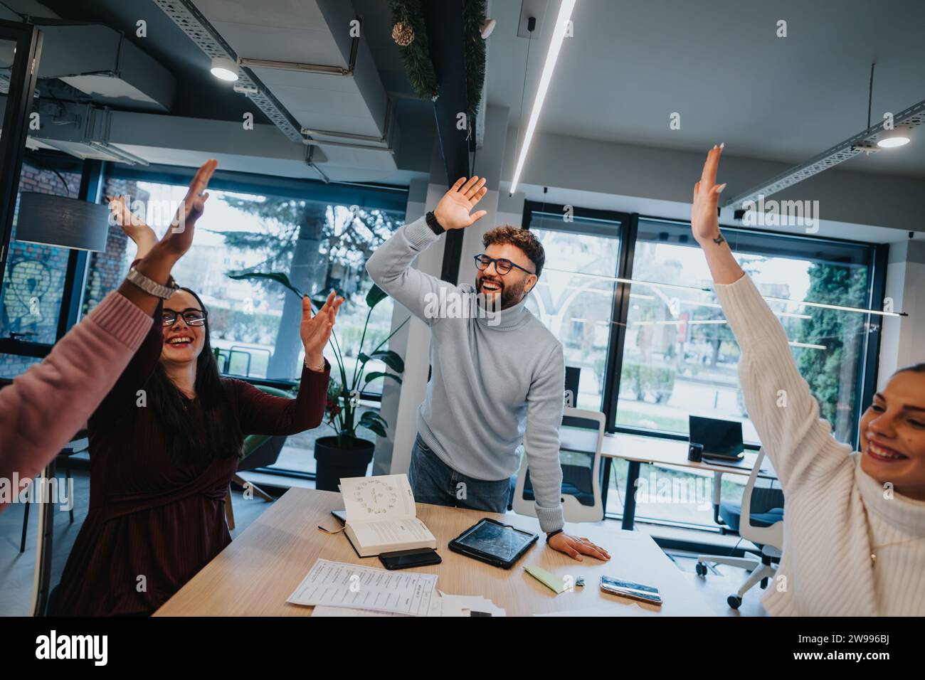 Multiracial colleagues celebrating a successful finished project with ...