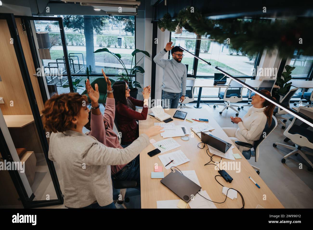 Amidst cheers, business partners unite hands, reveling in the success ...