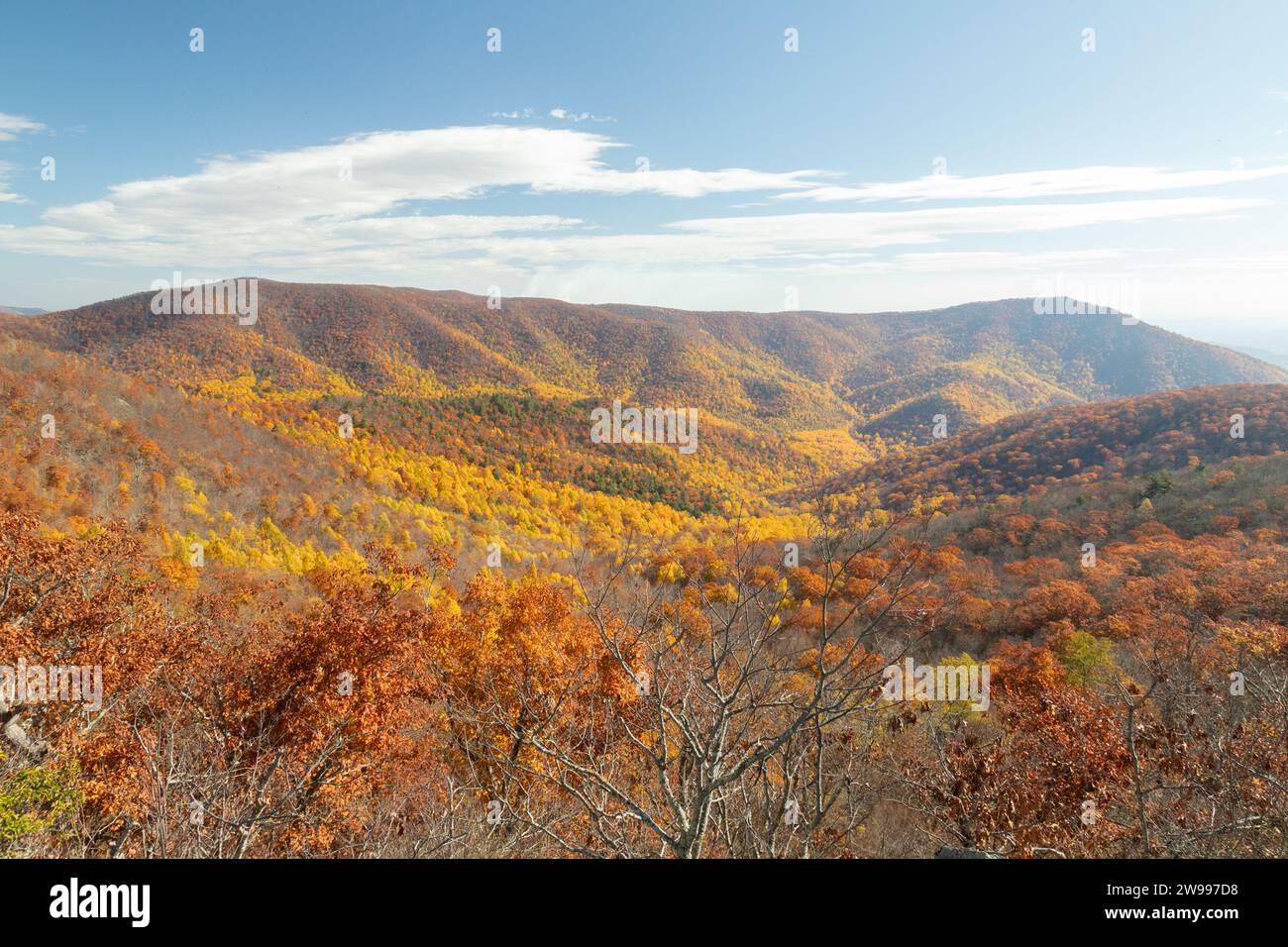 Colorful sunrise behind rolling mountains with red and orange fall ...