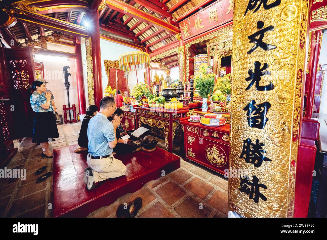 The Buddhist worshipers praying at the altars of Buddhist idols with ...