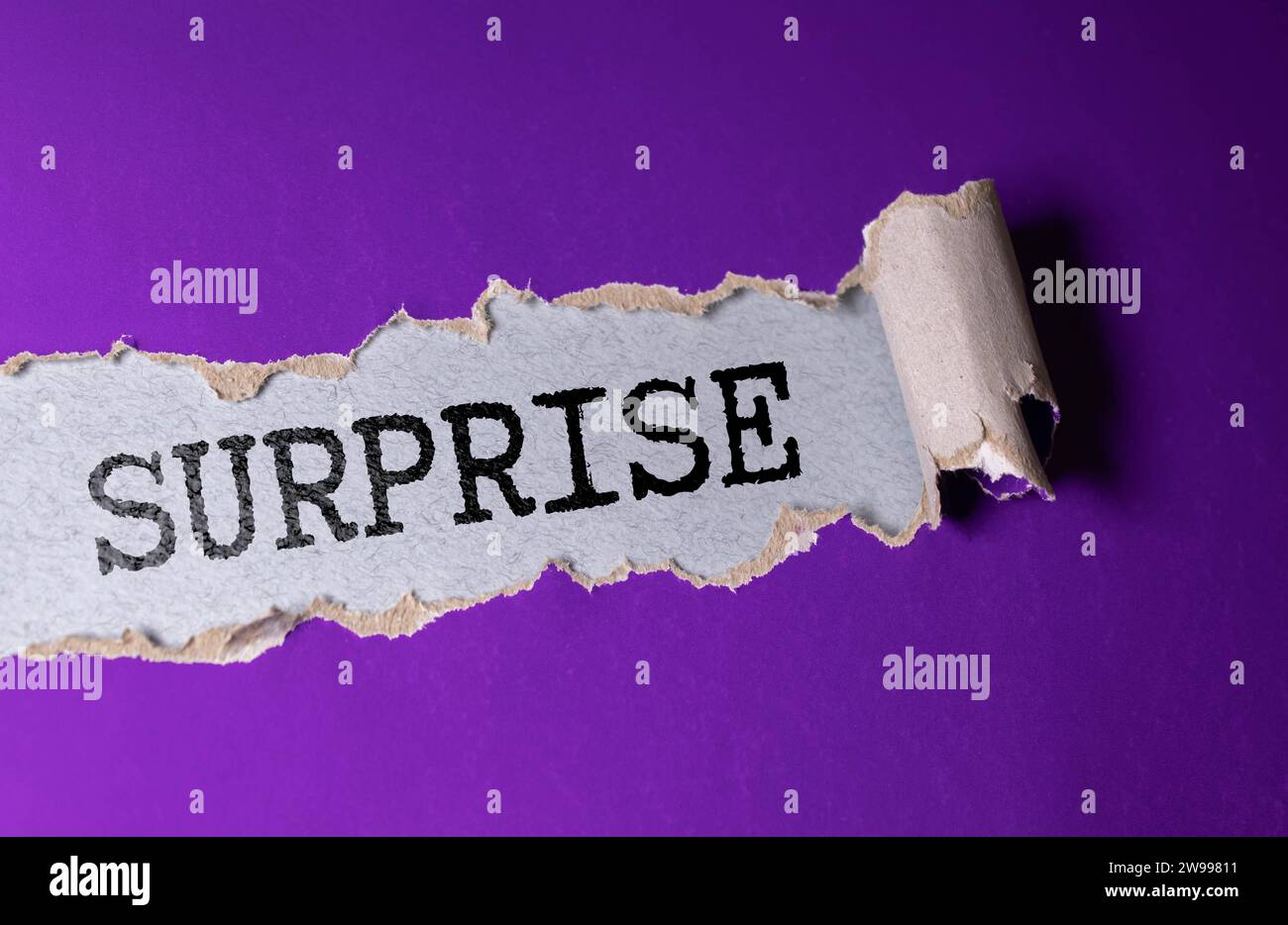 SURPRISE word written under torn paper Stock Photo - Alamy