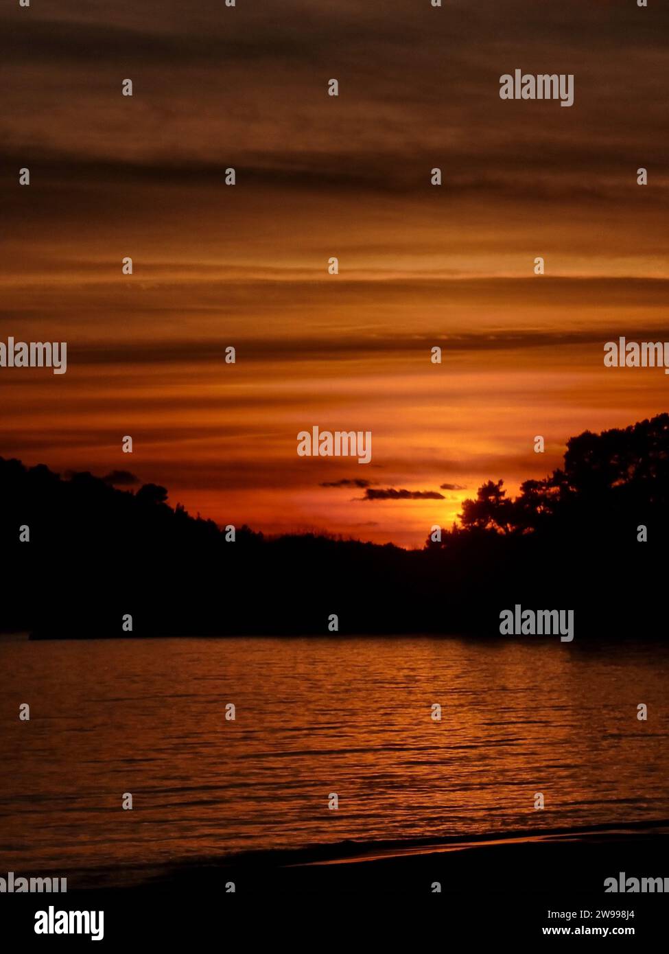 A breathtaking sunset is seen over the horizon of the ocean with a ...