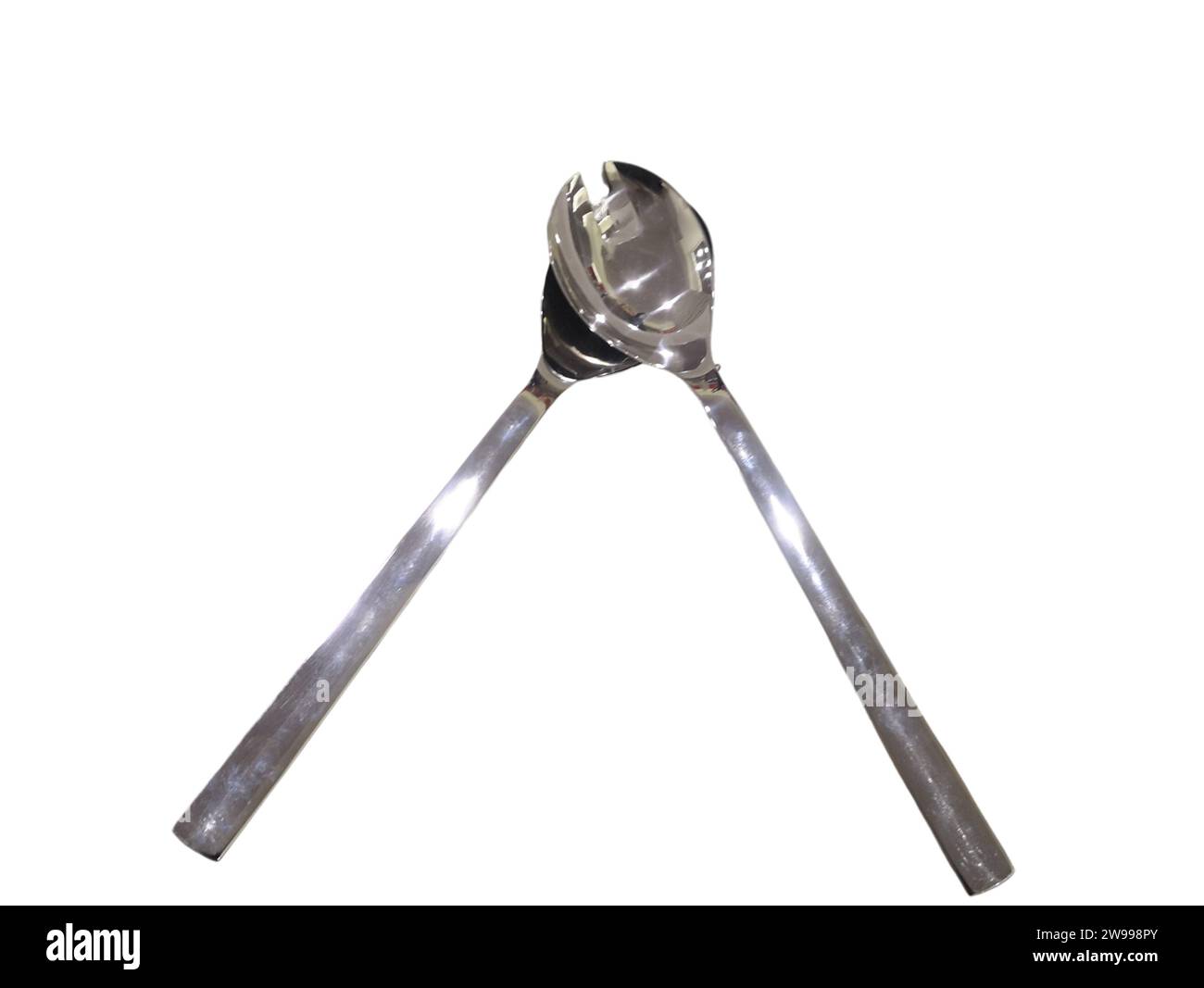 A metal spoon and tongs laying side-by-side on a flat surface Stock ...