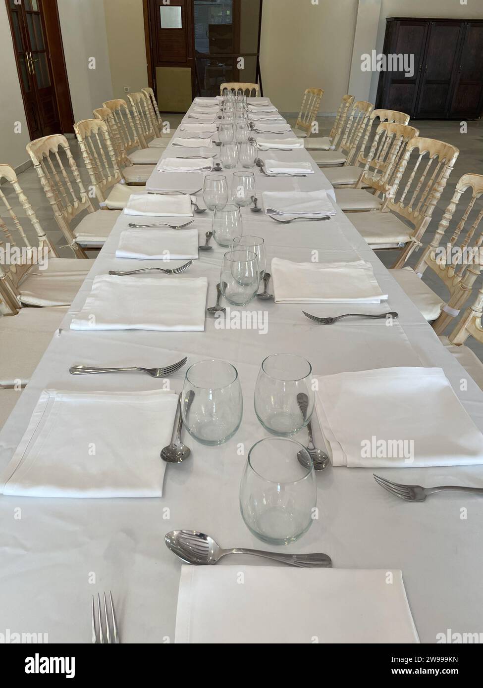 An inviting white table is beautifully set up with white place mats and ...