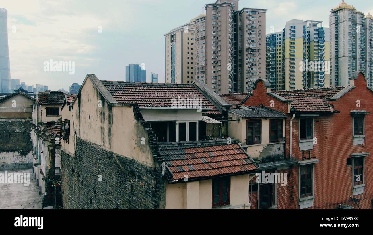 An aged red brick building situated among a cluster of high rise ...