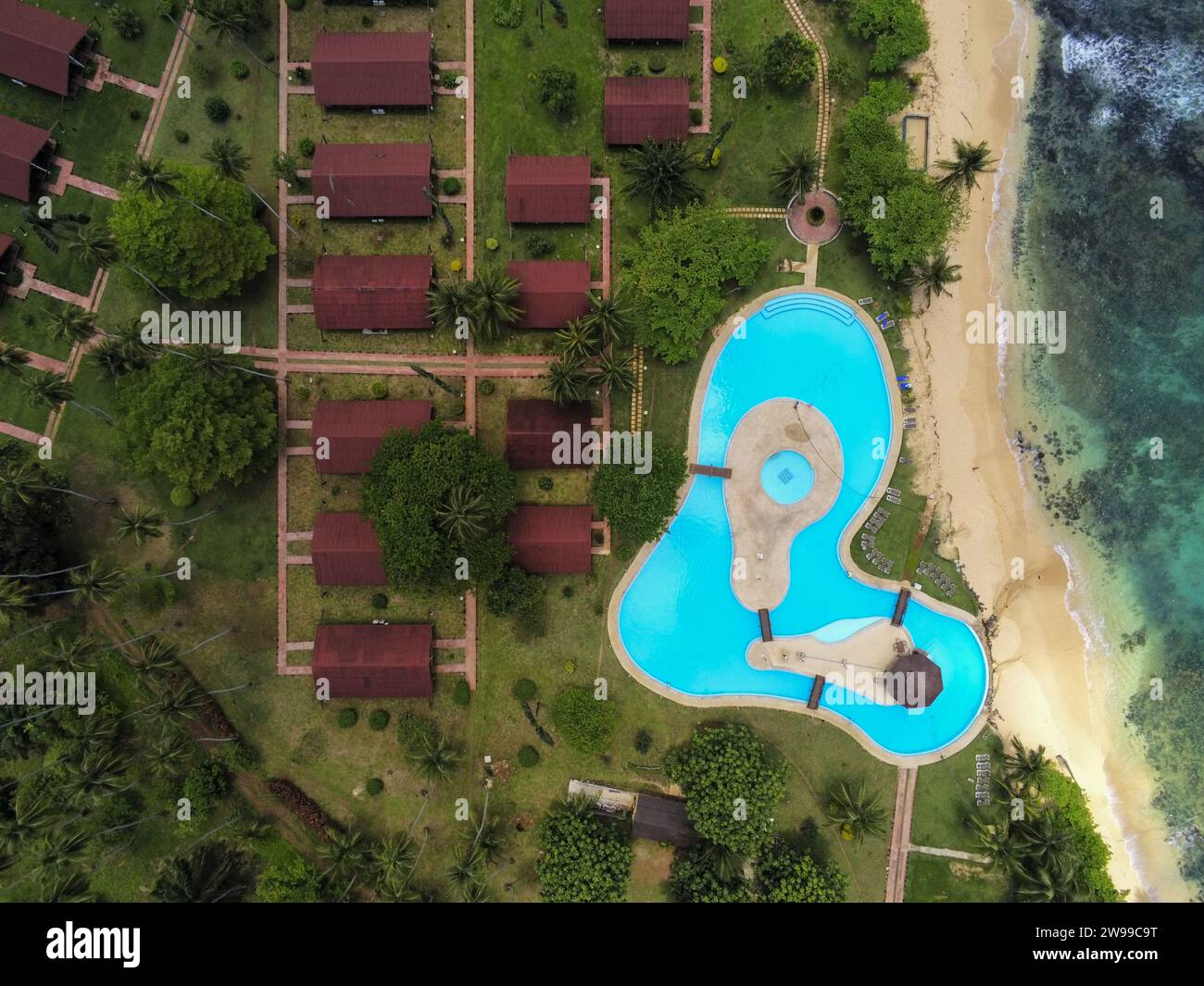 Aerial view over a pool in heart shape and bungalows at Ilheu das Rolas ...