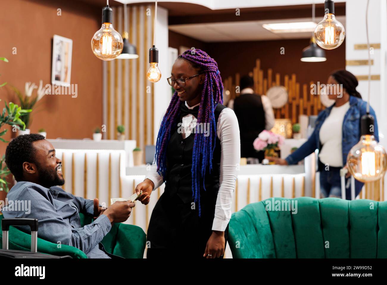 Smiling relaxed African American man traveler giving cash tip to happy ...