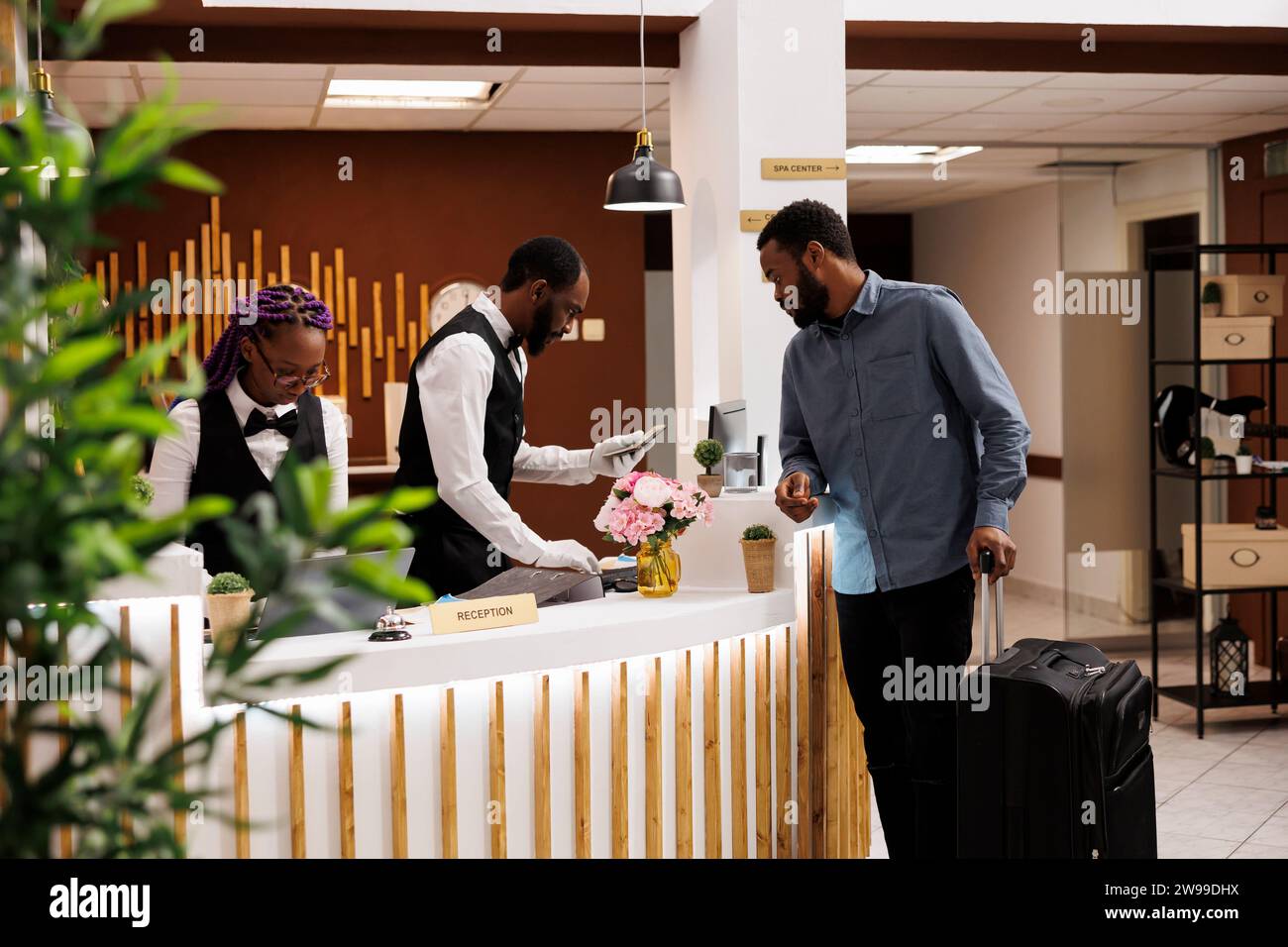 Front desk staff checking guest passport and travel documents during ...