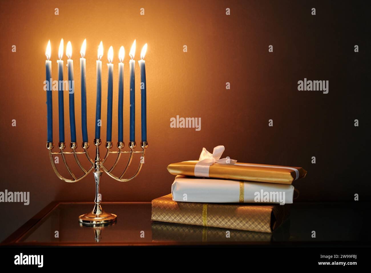 Stack of packed giftboxes and menorah with nine burning candles ...