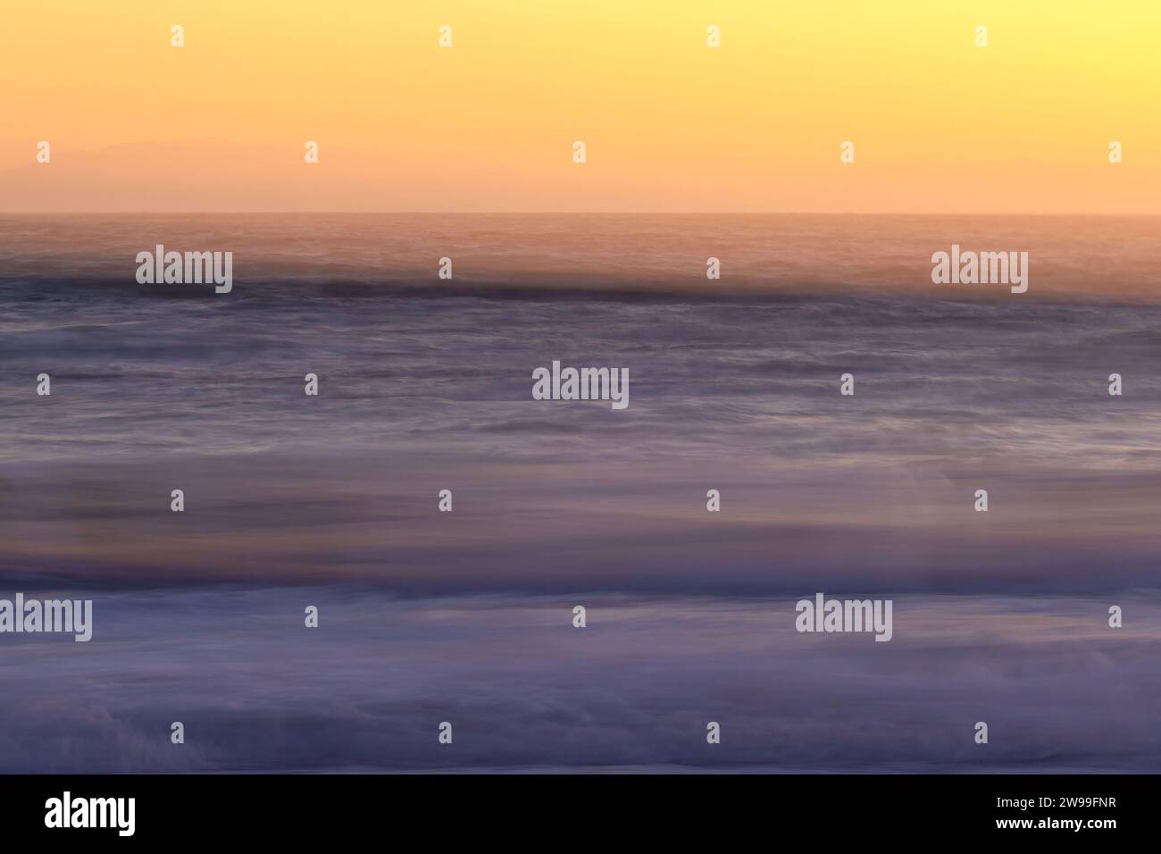 A young adult is riding a surfboard in the ocean waves, enjoying the ...